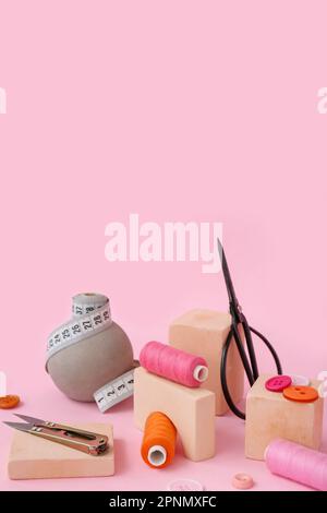 Podiums with tailor's supplies on pink background Stock Photo - Alamy