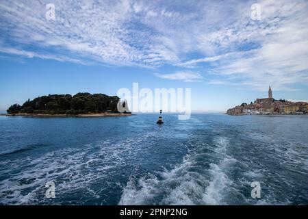 small island near Rovinj, Croatia with a clear blue sky and a calm blue ...