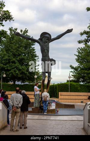 People venerating the statue of the Risen Christ in Medjugorje. The ...