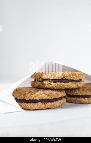 cookies packed in white parchment bags, chocolate filled oat cookies in ...