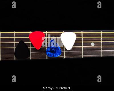 Three pick guitar on finger board background Stock Photo - Alamy