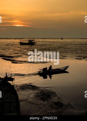 Fishing boat coming back home, sunset Stock Photo - Alamy