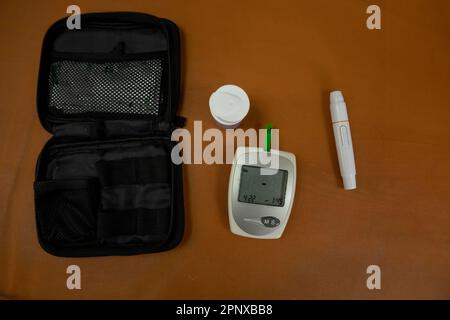 Glucometer on orange medical tissue Stock Photo - Alamy