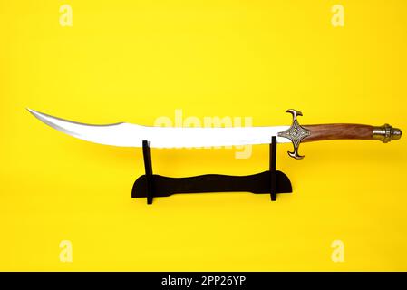 Scimitar sword blade, guard, and hilt isolated over blue Stock Photo ...