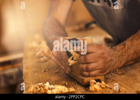 The wood artisan, a robust and strong man known as a carpenter, hand ...