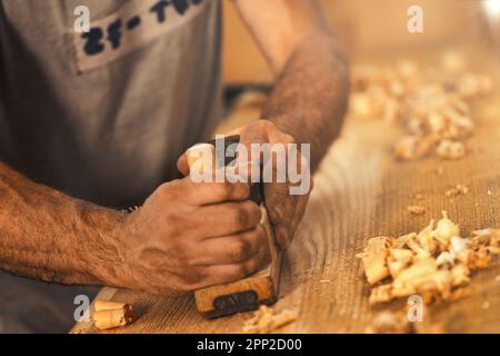 The wood artisan, a robust and strong man known as a carpenter, hand ...