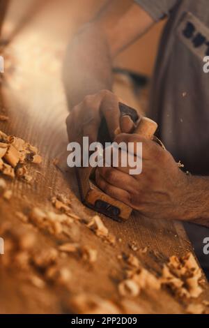 The wood artisan, a robust and strong man known as a carpenter, hand ...