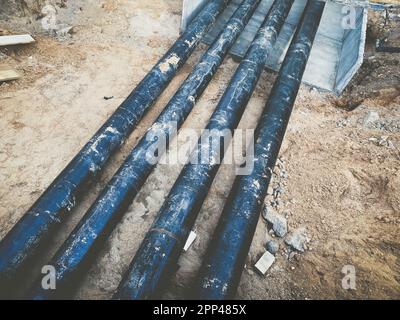black, polypropylene, long pipes are laid underground for communications. laying pipes for ...