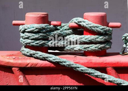 Red ship's bollard wrapped with ship's rope, mooring line, Germany ...