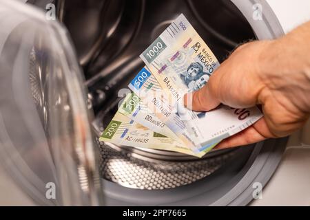 Mexican pesos being thrown into the washing machine, Concept, Money ...