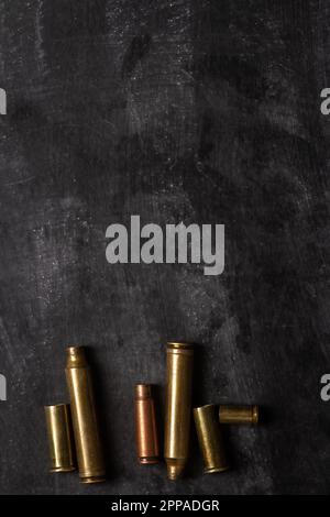 Empty bullet cartridges lying on the black background Stock Photo - Alamy