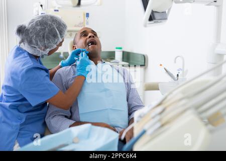 Dentist operates on patient - removes bad tooth Stock Photo - Alamy