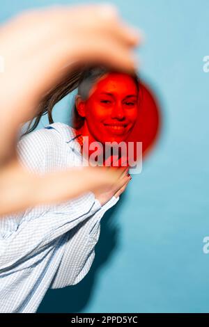 Woman seen through red lens filter against blue background Stock Photo ...