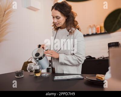 Home. Woman making tea in kitchen Stock Photo - Alamy