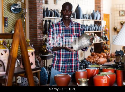 Male shop assistant in pottery shop Stock Photo - Alamy