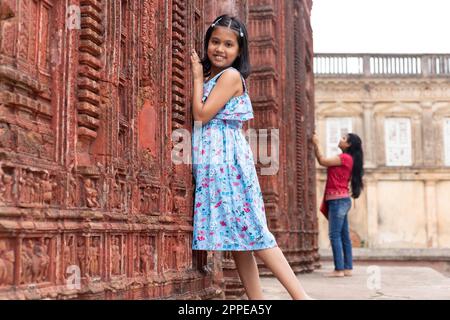 A pretty Indian girl child near a terracotta temple of West Bengal ...