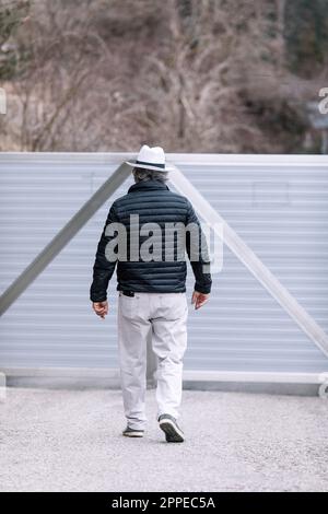 A man walking to his automatic gate, coming home from work, the ...