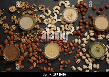 Different types of delicious nut butters and ingredients on brown ...