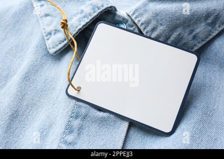 Blank tag on denim shirt, closeup view with space for text. Banner ...