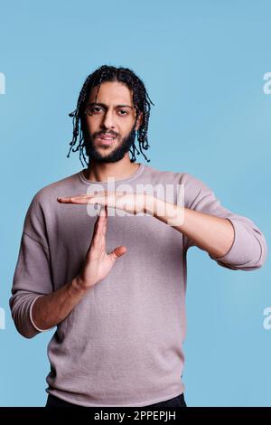 Young arab man doing stop gesture with hand at street Stock Photo - Alamy