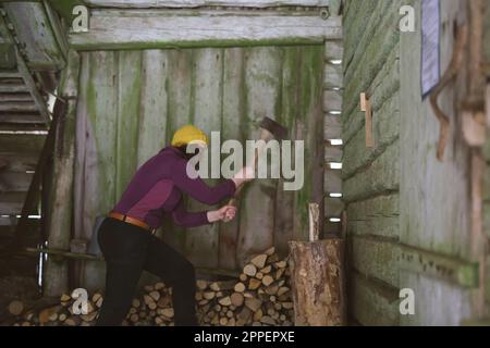 Woman chopping wood in shed Stock Photo - Alamy