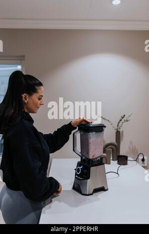 Woman using blender in kitchen Stock Photo - Alamy