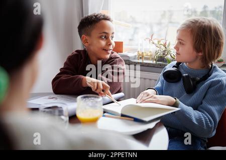 Two boys doing homework at dining table Stock Photo - Alamy