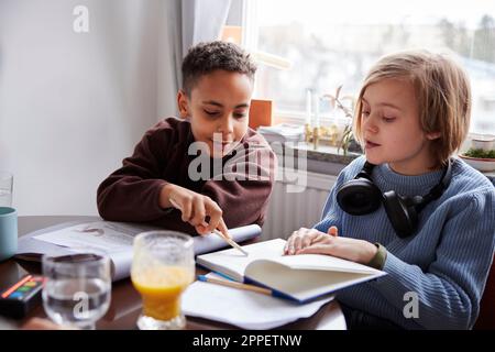 Two boys doing homework at dining table Stock Photo - Alamy