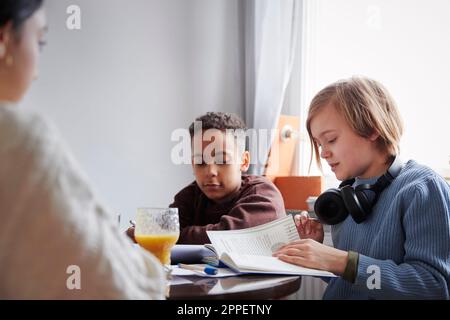 Two boys doing homework at dining table Stock Photo - Alamy