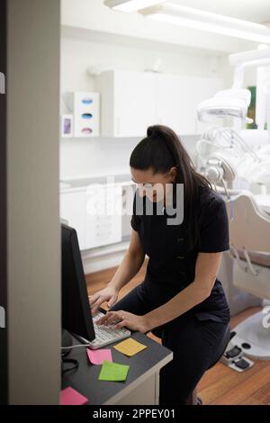 Female dentist writing in office Stock Photo - Alamy
