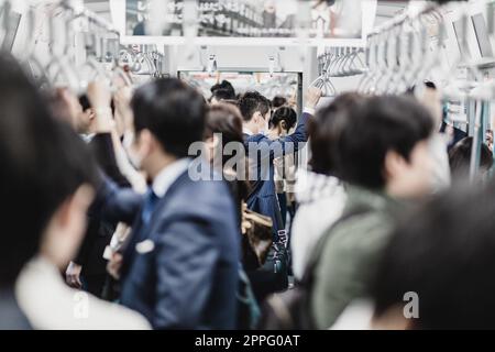 Passengers traveling by Tokyo metro. Business people commuting to work ...