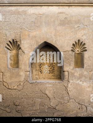Perforated arched stucco window decorated with floral patterns, one of ...