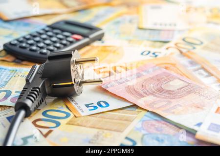 Electric plug, calculator and euro money on the wooden table. Concept ...