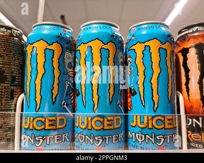 Cans of Monster Energy drink on sale on a shelf in a supermarket in the ...