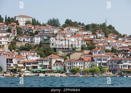 Many small houses on the coast of the Lake Ohrid with docks and moored ...