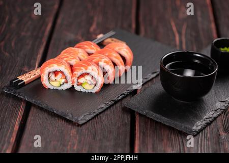 Sushi roll maguro with tuna, smoked eel, avocado and tobiko on black ...