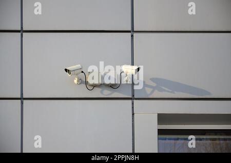White surveillance camera built into the metal wall of the office ...