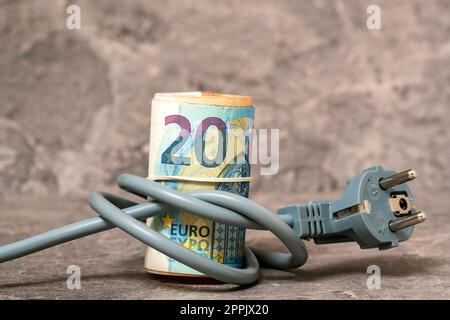 Electric plug and roll of euro currency Stock Photo - Alamy