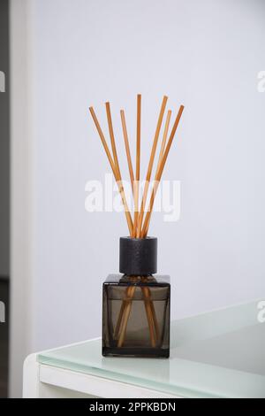 Aromatic reed freshener on table near white wall Stock Photo - Alamy