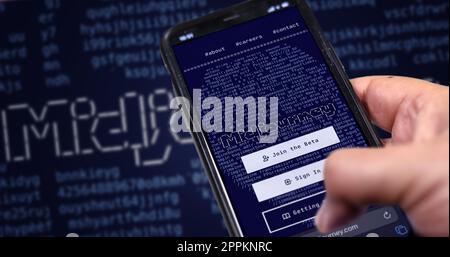 AI Midjourney logo on the phone screen on the background of the server room. Smartphone with ...