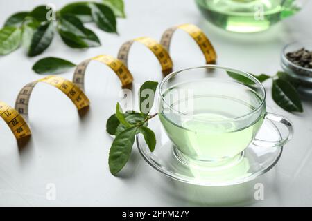 Cup of tea and measuring tape on table. Weight loss concept Stock Photo ...
