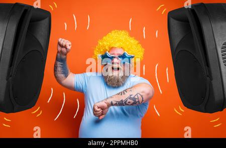 Fat amazed man with beard ,tattoos and wings acts like an angel Stock ...