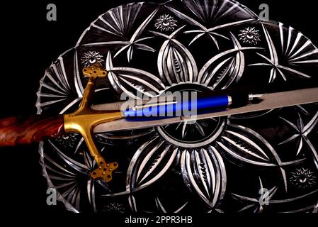 Medieval Sword and pen isolated over a black background Stock Photo - Alamy