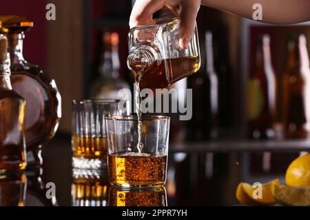Woman pouring rum from bottle into glass on white background Stock ...