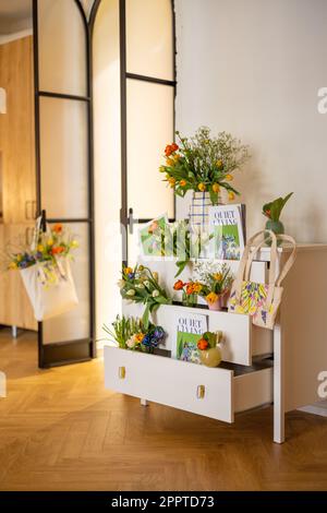 Lots of fresh cutted flowers in white commode indoors Stock Photo - Alamy