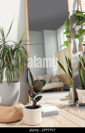 Sofa, table and floor mirror near white wall in interior of room Stock ...