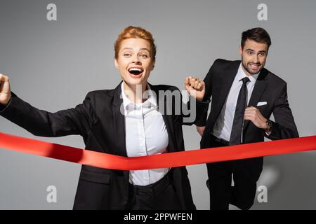 happy young businesswoman running near office building while holding ...