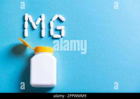 Mineral pill capsule Magnesium. White vitamin pills forming shape to Mg ...