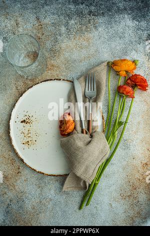 Rustic table setting with ranunculus flowers on concrete background ...