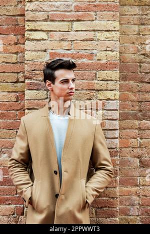 Young elegant man wearing winter coat over isolated background with ...